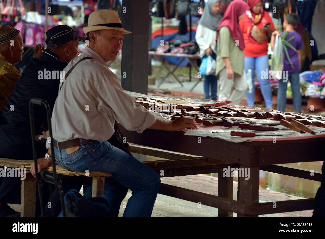 An indigenous Bajau man selling traditional knives at the Sunday market ...