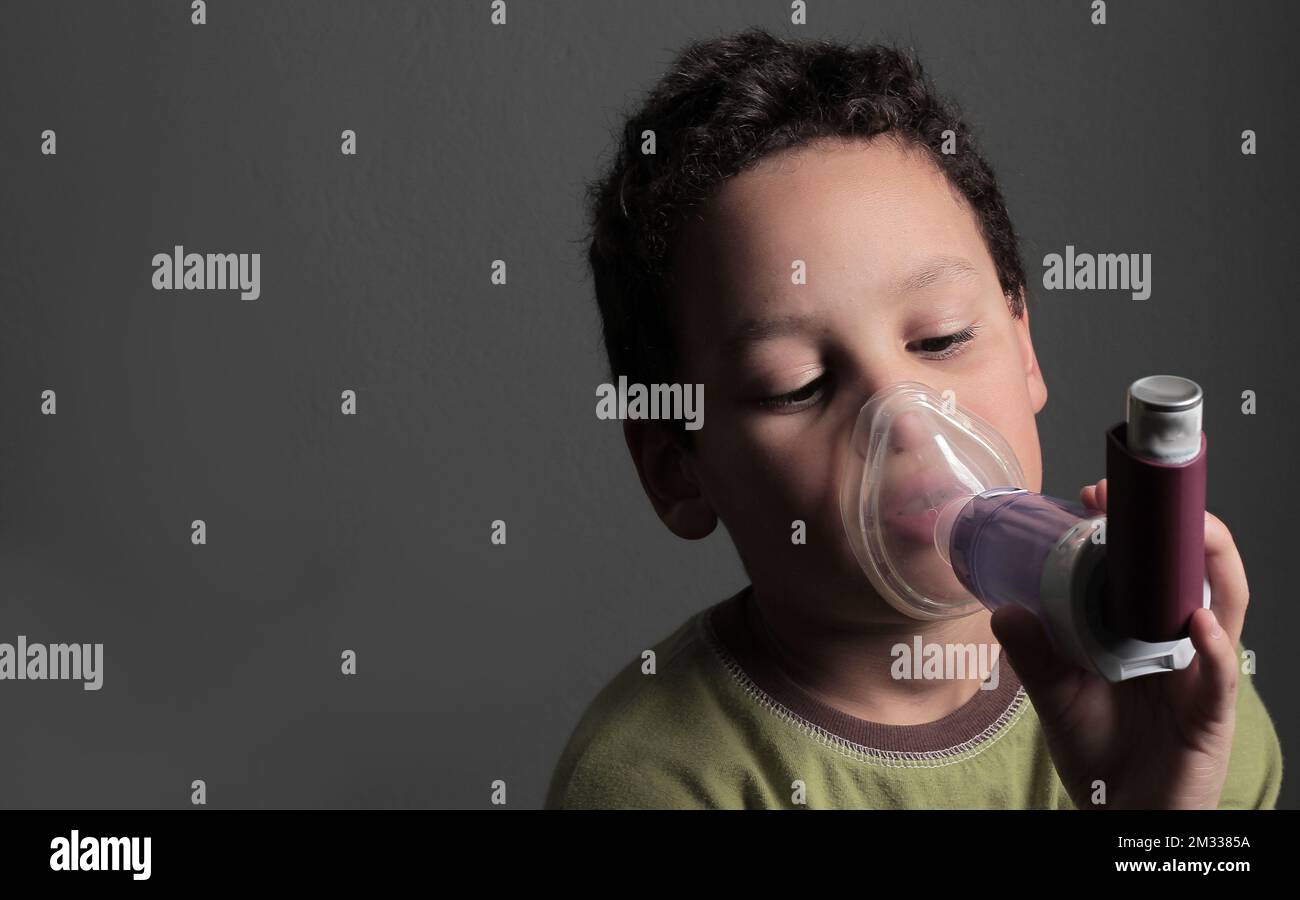 child with flu and inhaler respiratory puff on grey background with ...