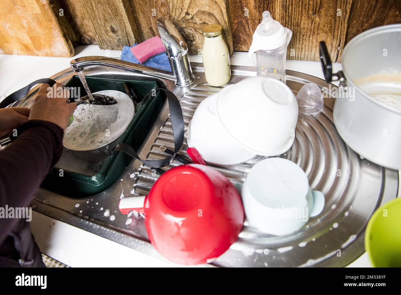 Illustration picture shows a guest doing the dishes at a communal sink ...