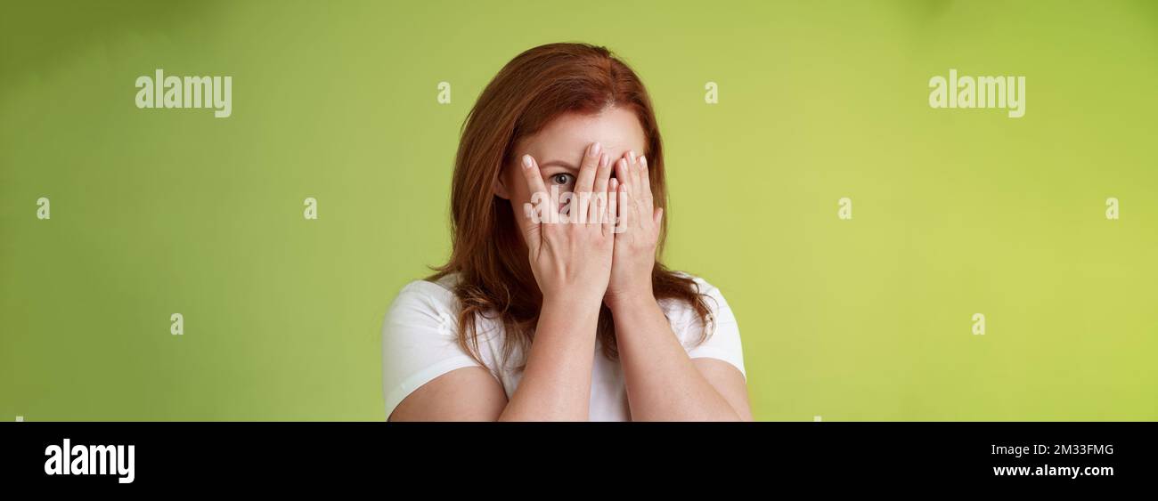 Not peeking. Playful charismatic middle-aged ginger redhead woman close ...