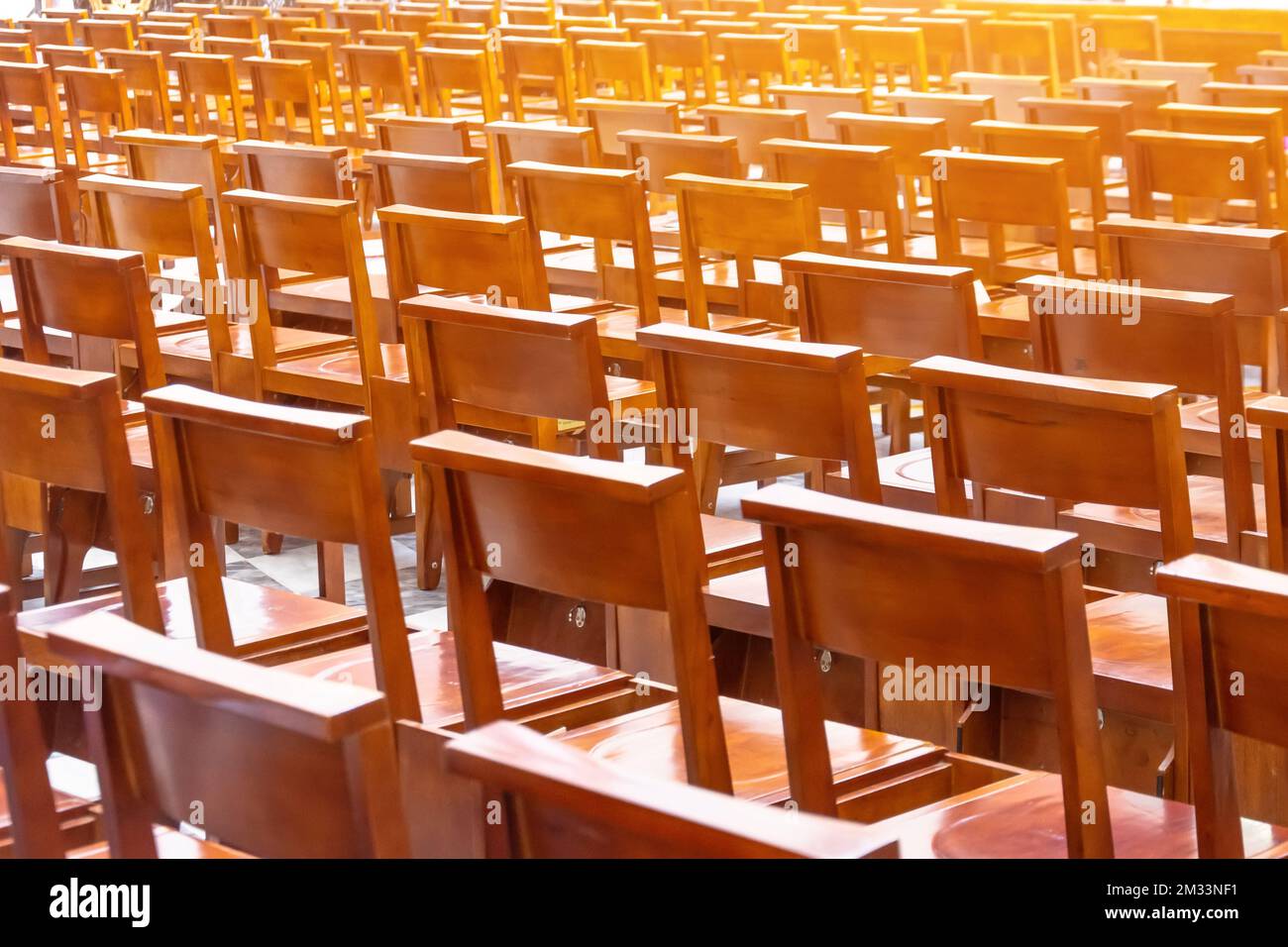 Chairs in the church in the prayer hall, wooden brown armchairs in rows ...