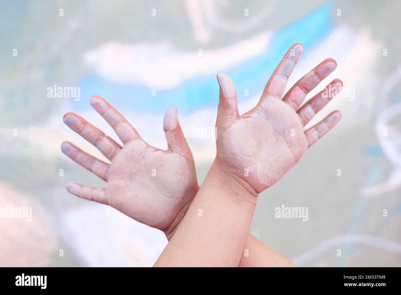 Child hands stained with colored chalk isolated on abstract drawing ...