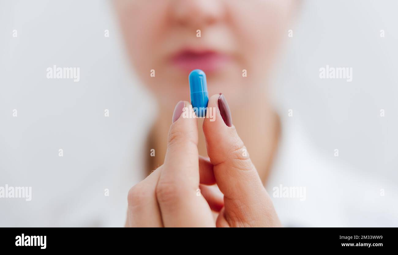 Women's hand with blue pill, vitamin, capsule. Medical insurance ...