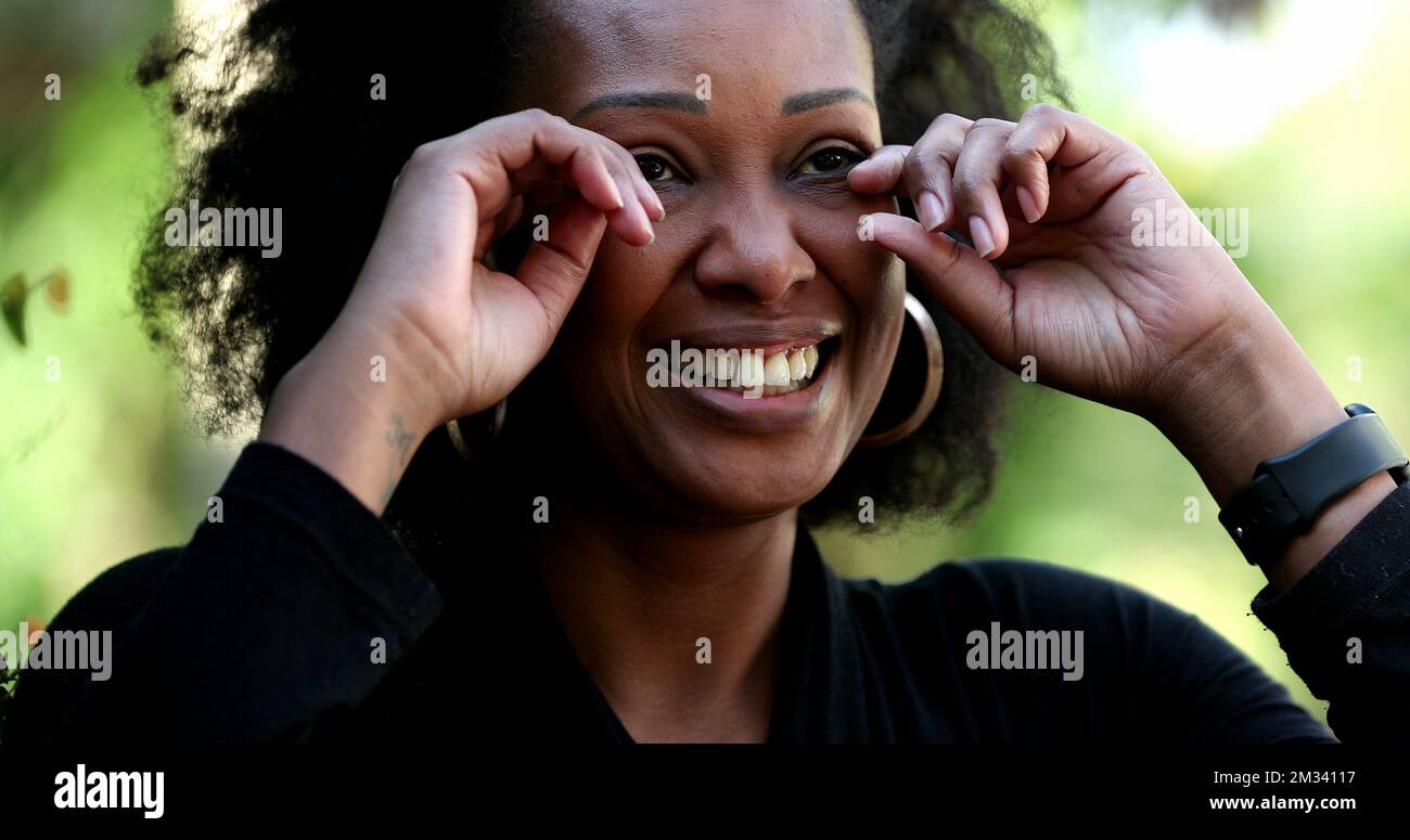 Woman wiping tears with fingers Stock Photo - Alamy