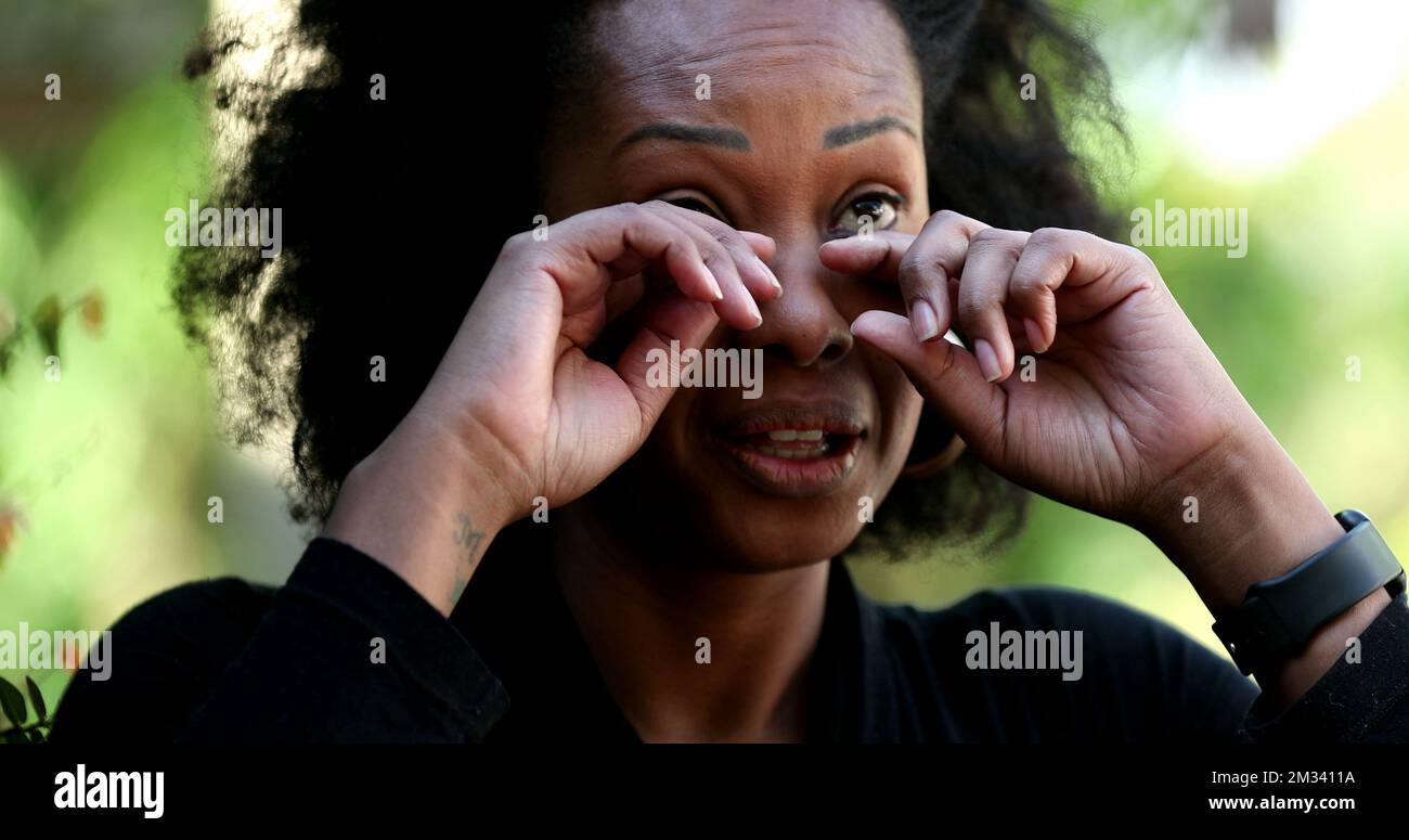 Woman wiping tears with fingers Stock Photo - Alamy