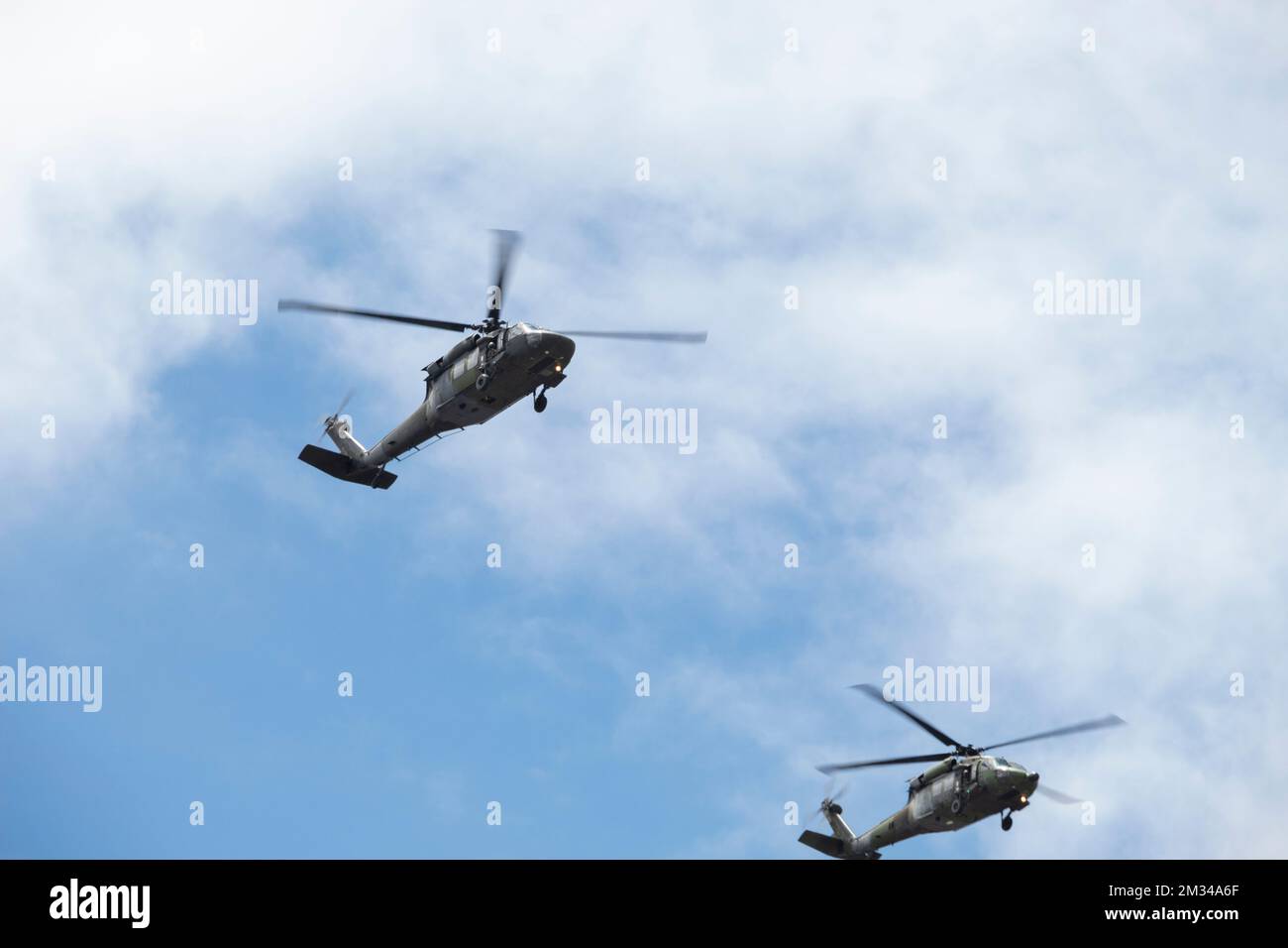 two army helicopters flying over crowd during independence day military ...