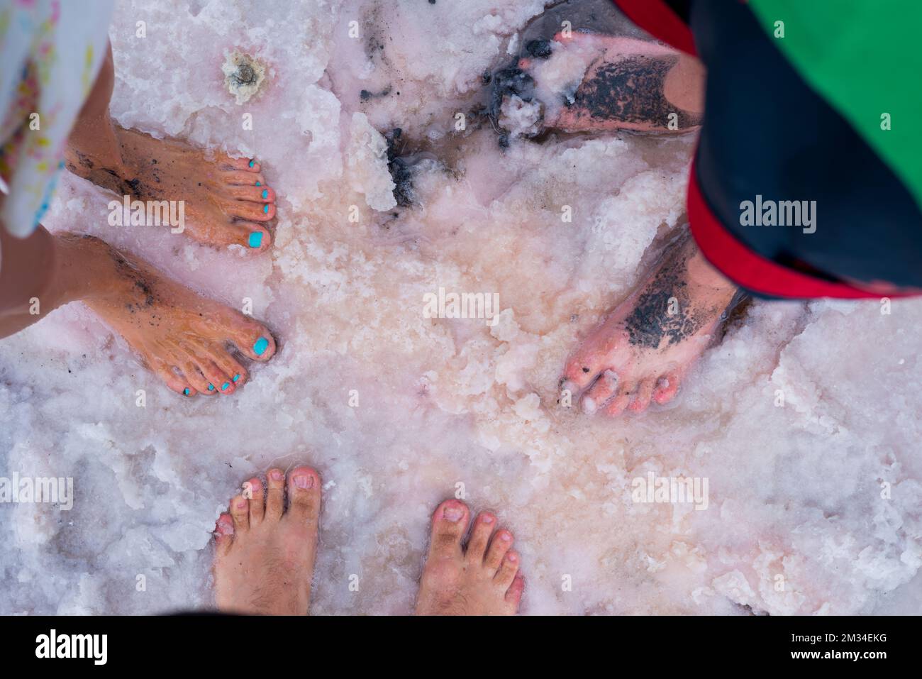 Feet of three friends on a salt lake, top view Stock Photo - Alamy