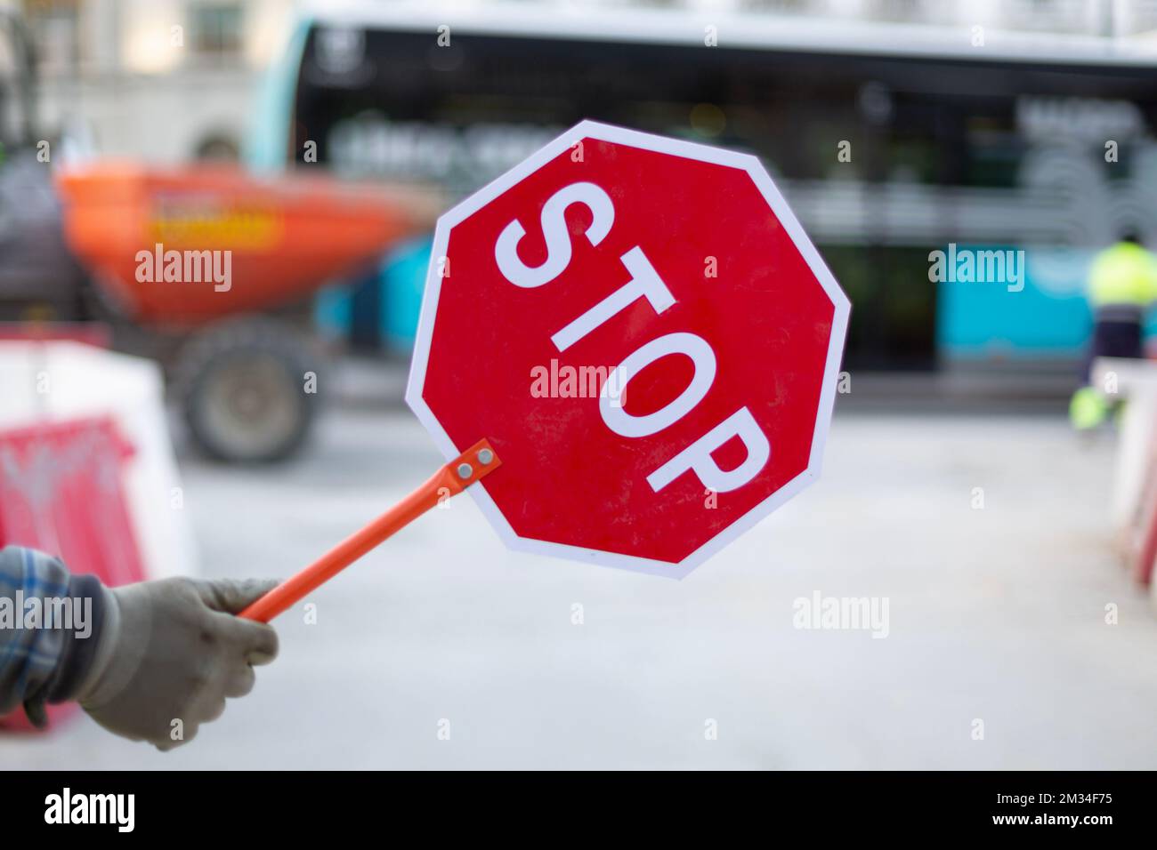 Person directing the traffic for works. Detail of hand holding a stop ...