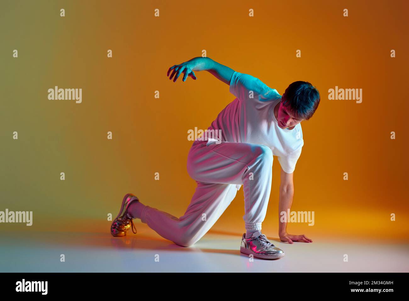 man dancing on yellow background. Neon lighting Stock Photo - Alamy