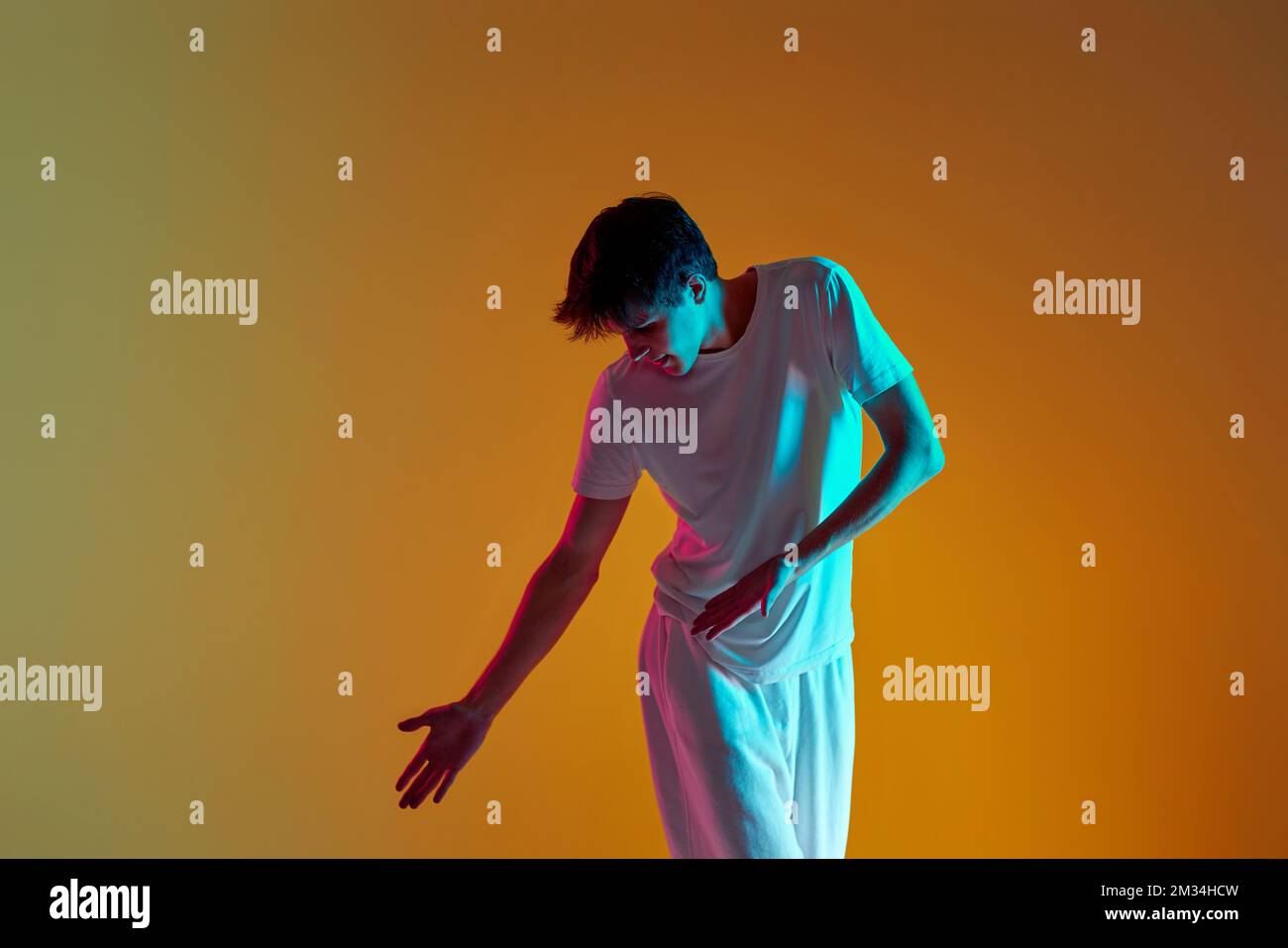 man dancing on yellow background. Neon lighting Stock Photo - Alamy