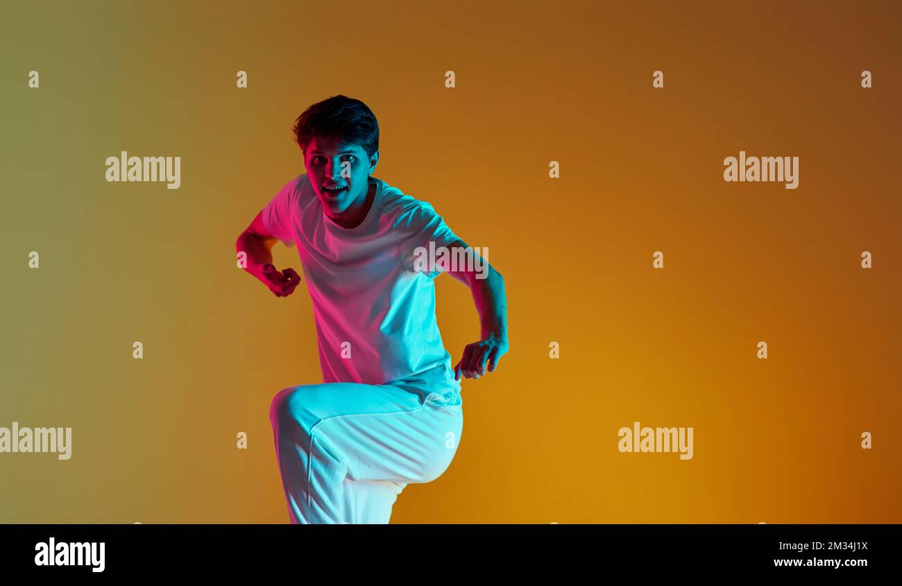 man dancing on yellow background. Neon lighting Stock Photo - Alamy