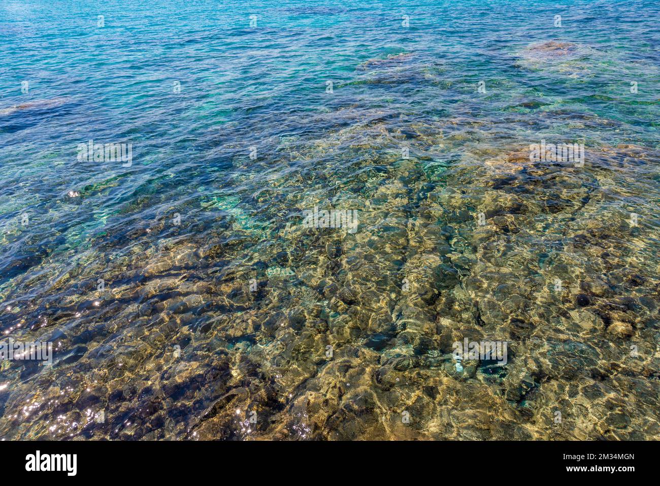 A beautiful view of rippling sea water with pebbles on the bottom, can ...