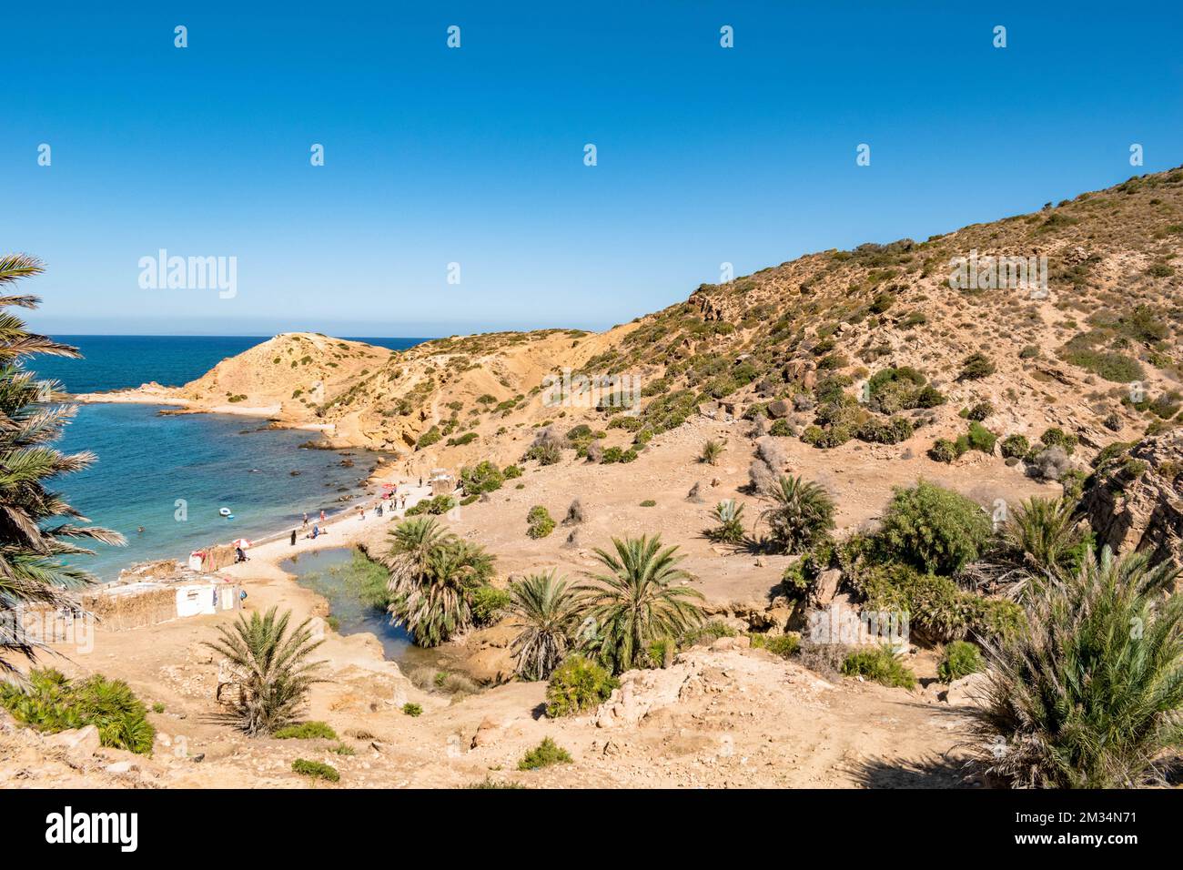 Arid sandy mountains with green vegetation on the coast of Korbous ...