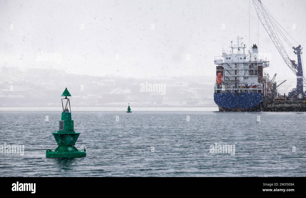 Loading of a cargo ship in port of Reykjavik on a cold snowy winter day ...