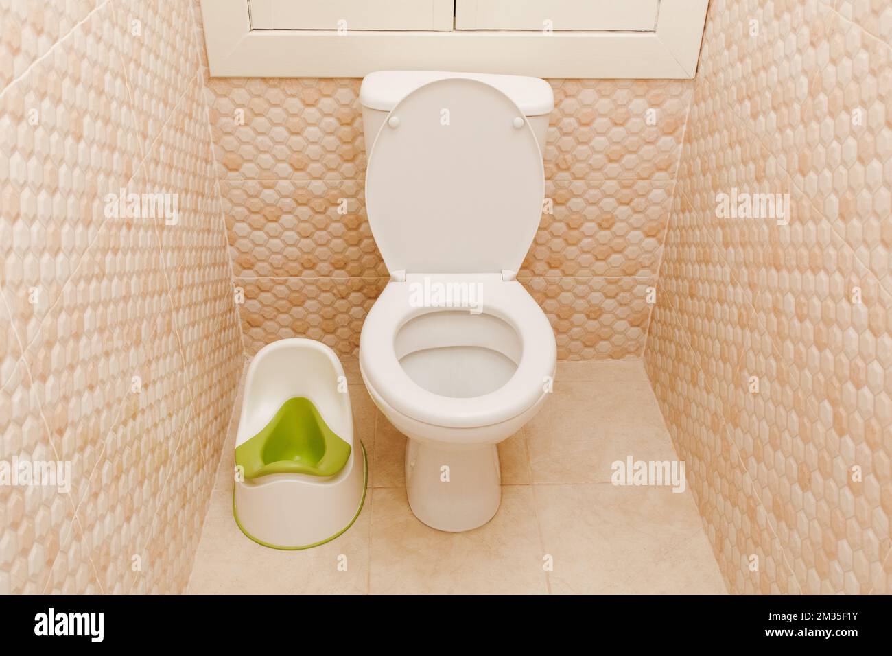 Baby green potty in toilet. Hygiene. Children's toilet. Children's pad ...