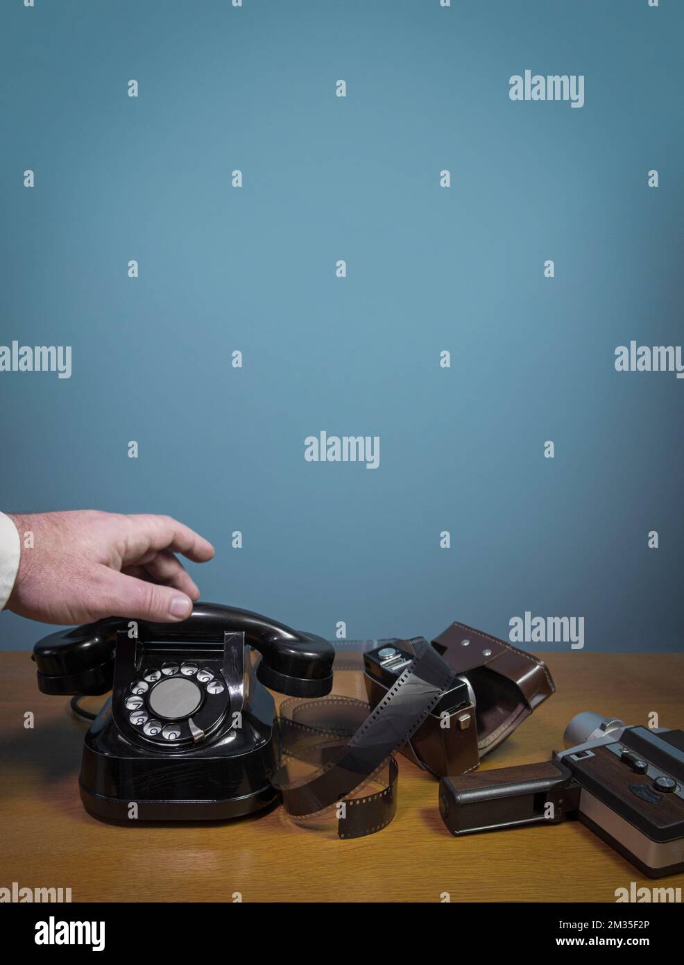 Old movie camera, film, old phone, old camera. A man's hand takes the ...