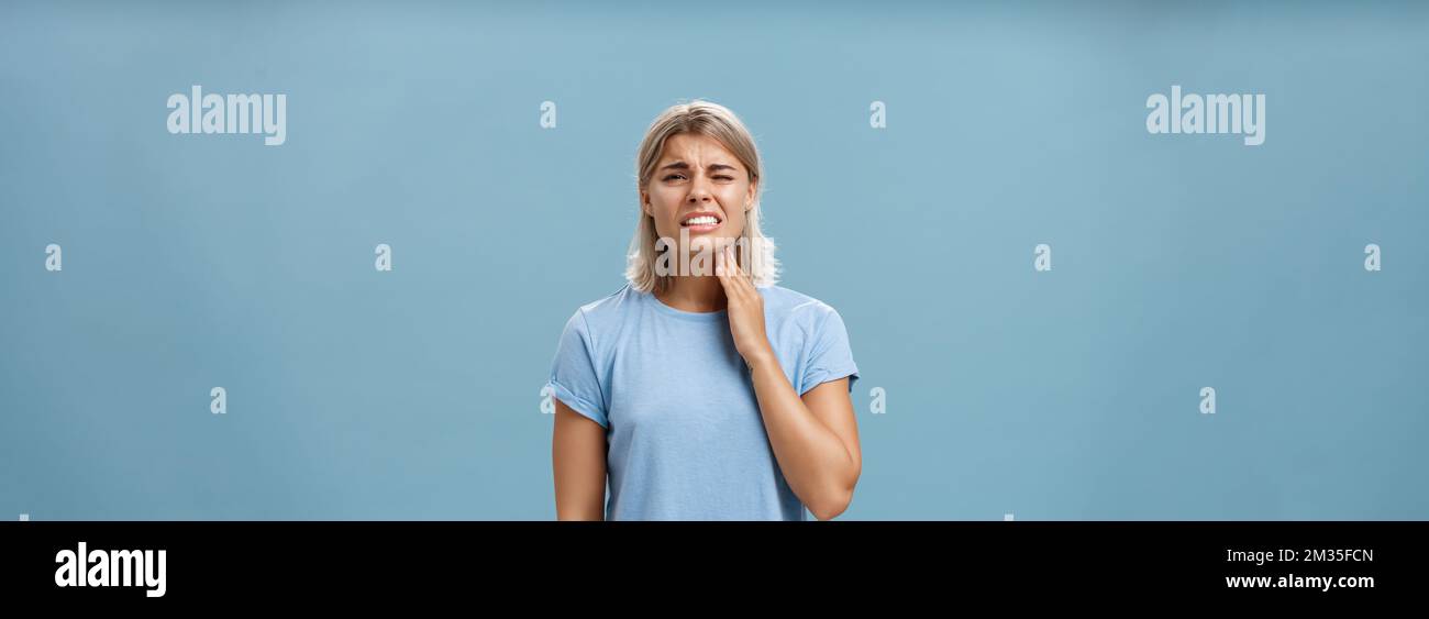 Ouch my throat. Displeased unhappy good-looking adult blonde girl with ...