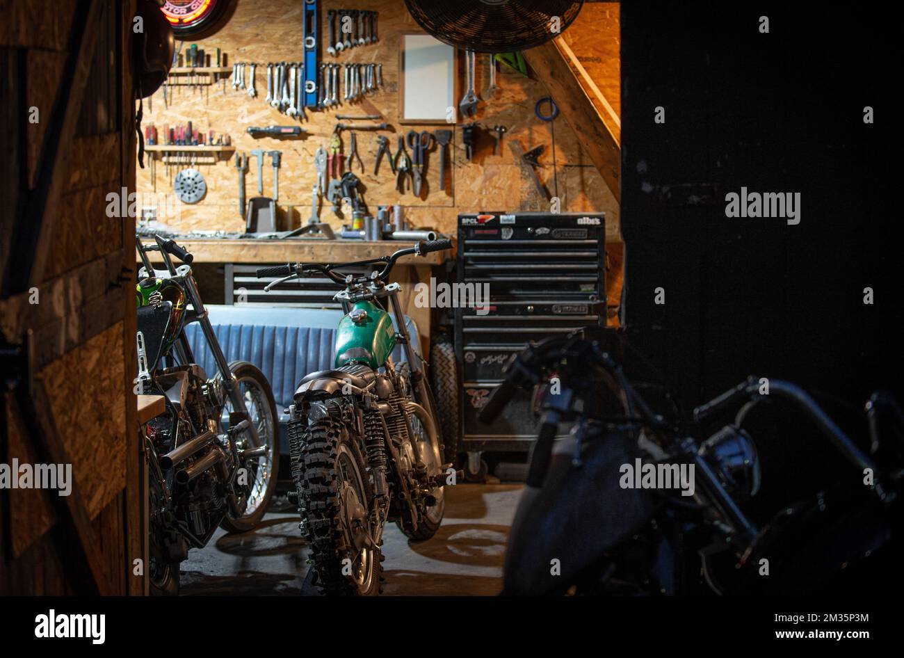 An inside view of a garage with motorcycles and instruments on the wall ...