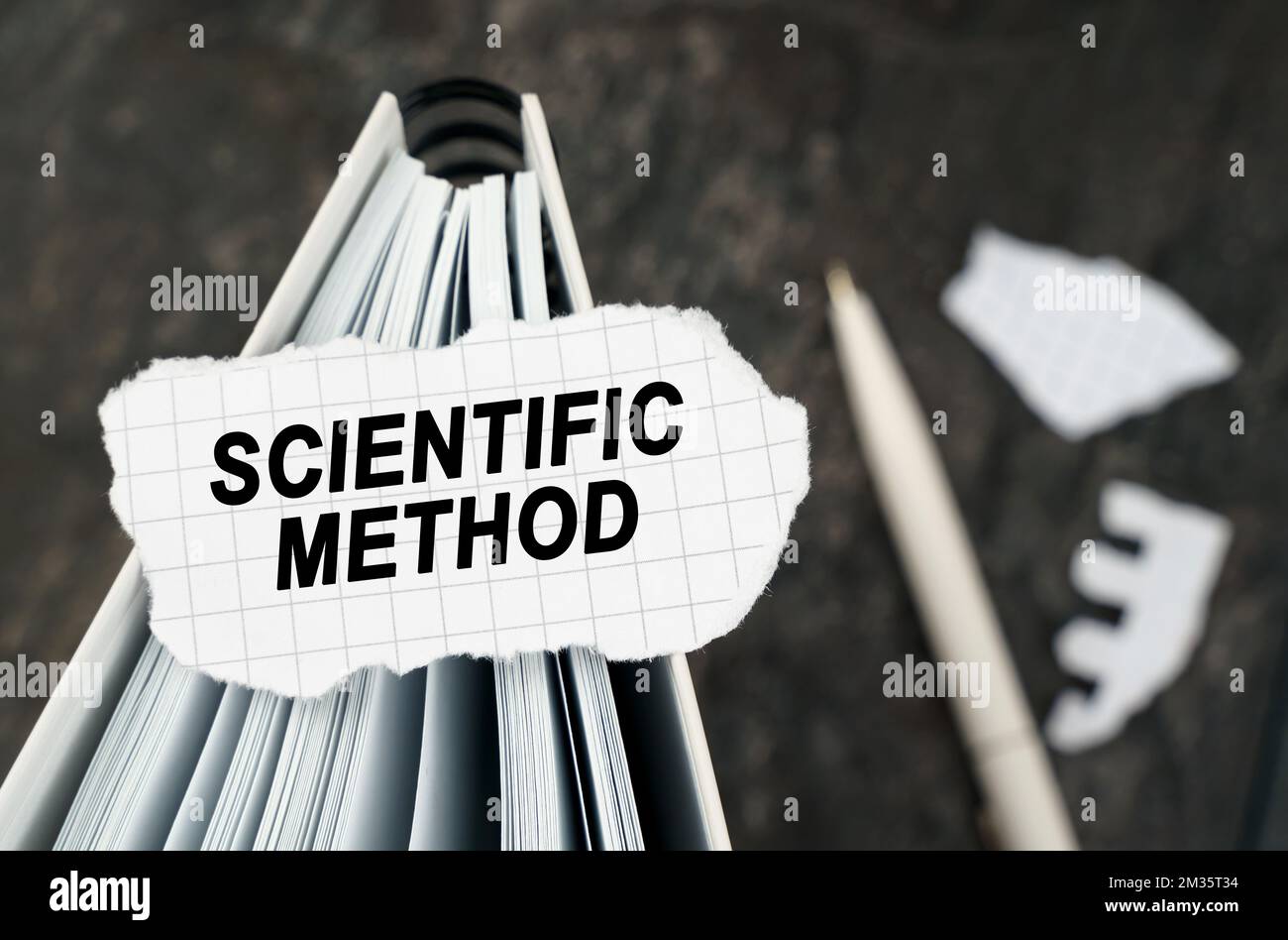 On the table is a notebook on which lies a piece of torn paper with the ...