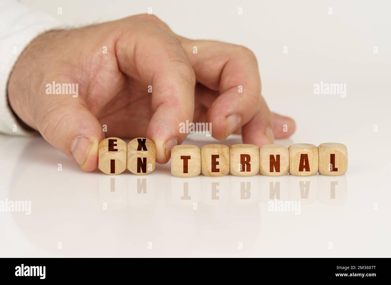 The man has cubes in his hands that form the words external - internal ...