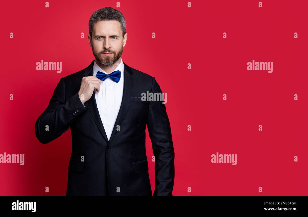man in formalwear tuxedo isolated on red background with copy space ...