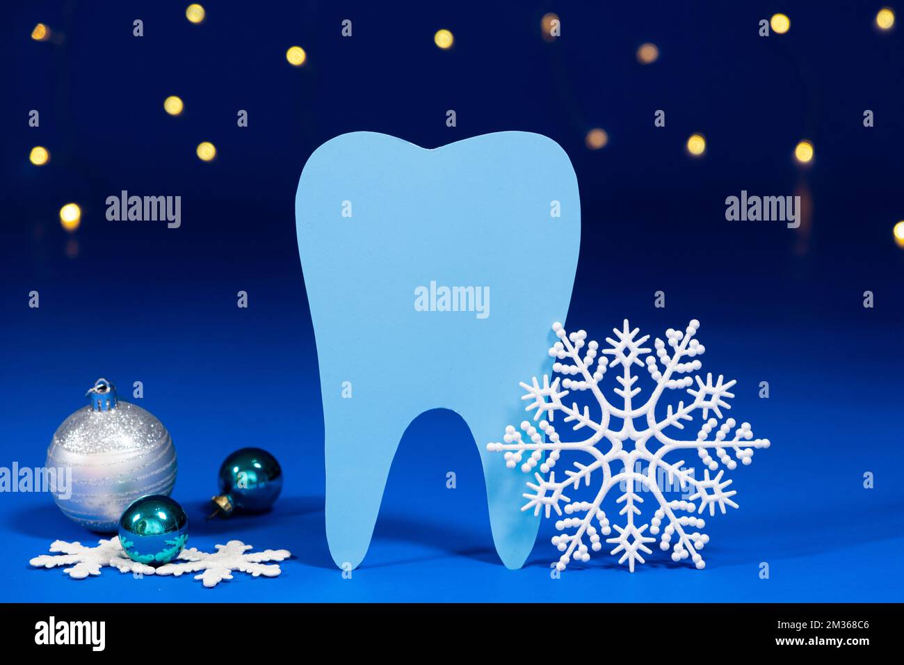 Christmas dentistry - tooth, snowflakes and balls on a blue festive ...