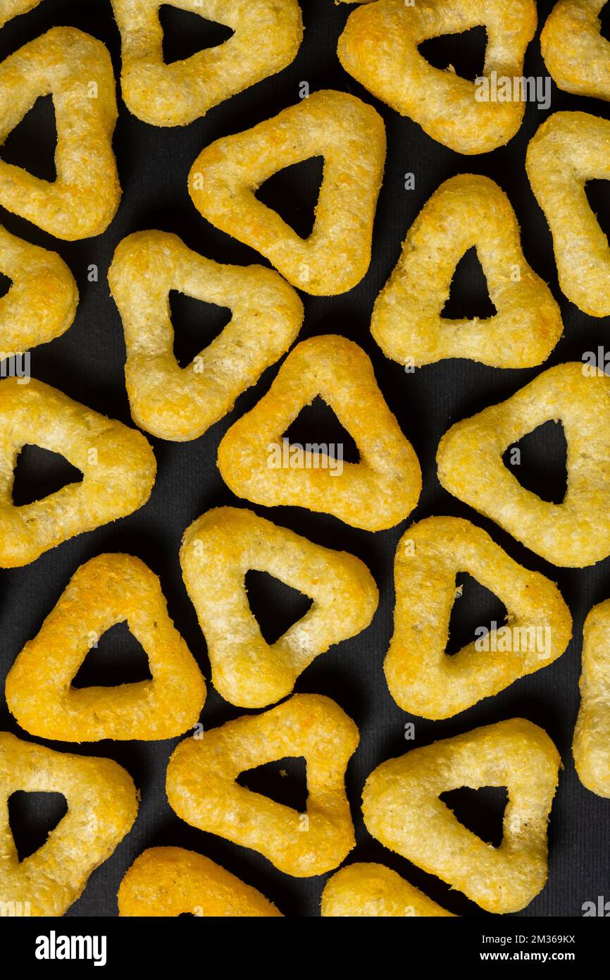 Delicious crispy corn chips triangular shape with spices on a black ...