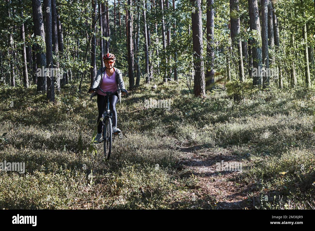 Active Woman Cycling On Forest Road Female Riding Bicycle Off Road