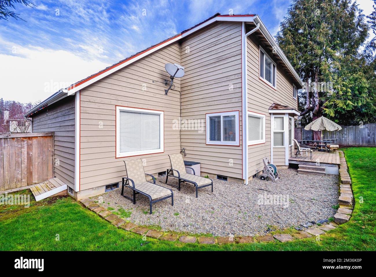 A Suburban Backyard showing a bay window, wooden deck, lounge chairs ...