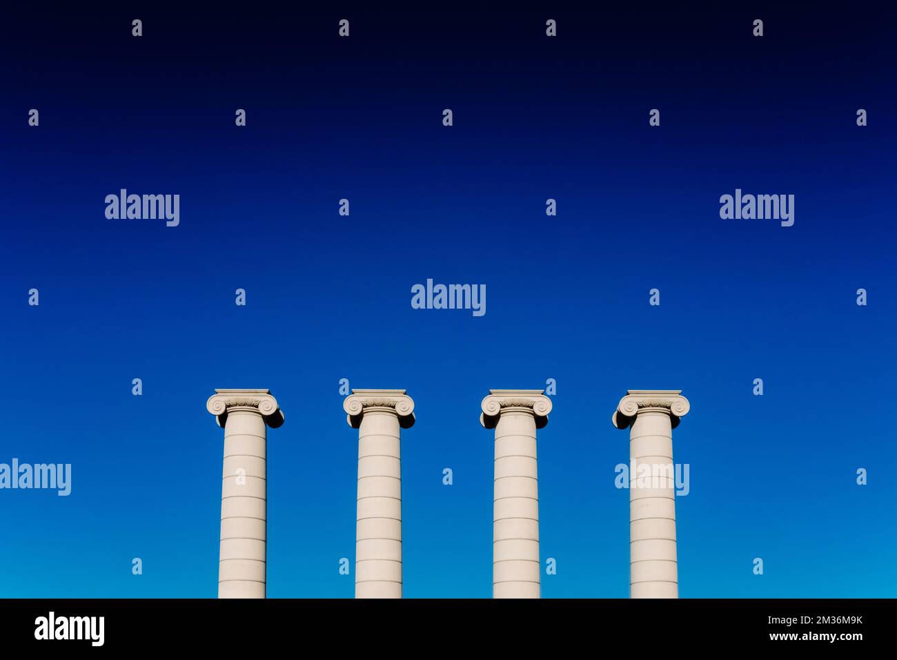 Four classical ionic columns, isolated on blue sky background Stock ...