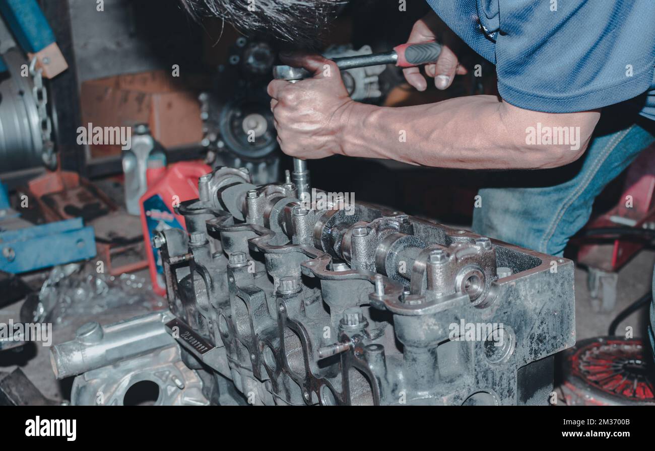 The auto mechanic repairing the engine of a car on the blurred ...