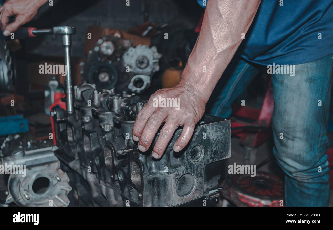 The auto mechanic repairing the engine of a car on the blurred ...