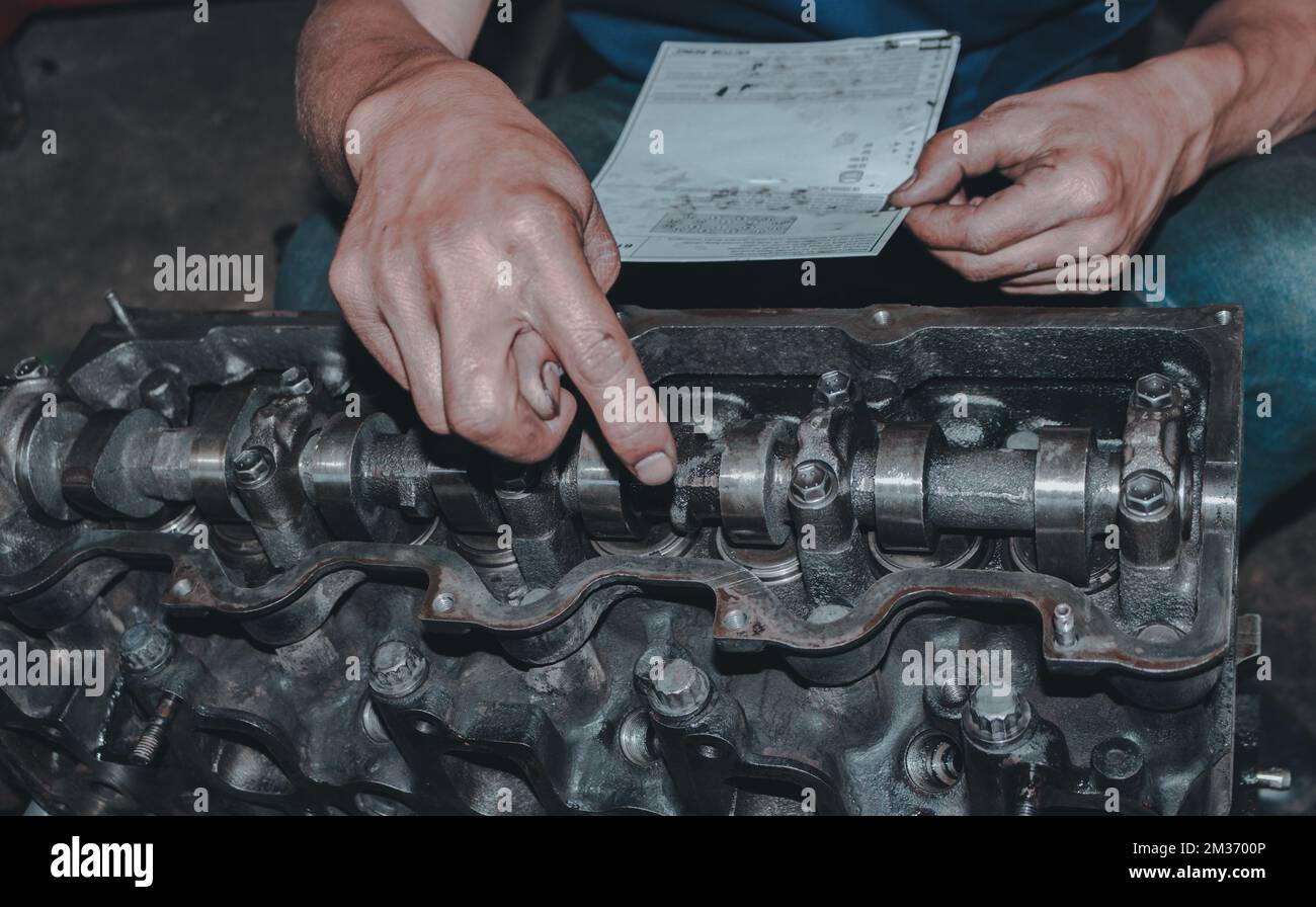 The auto mechanic repairing the engine of a car on the blurred ...