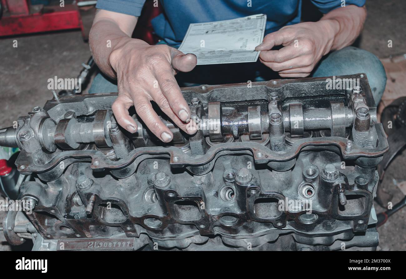 The auto mechanic repairing the engine of a car on the blurred ...