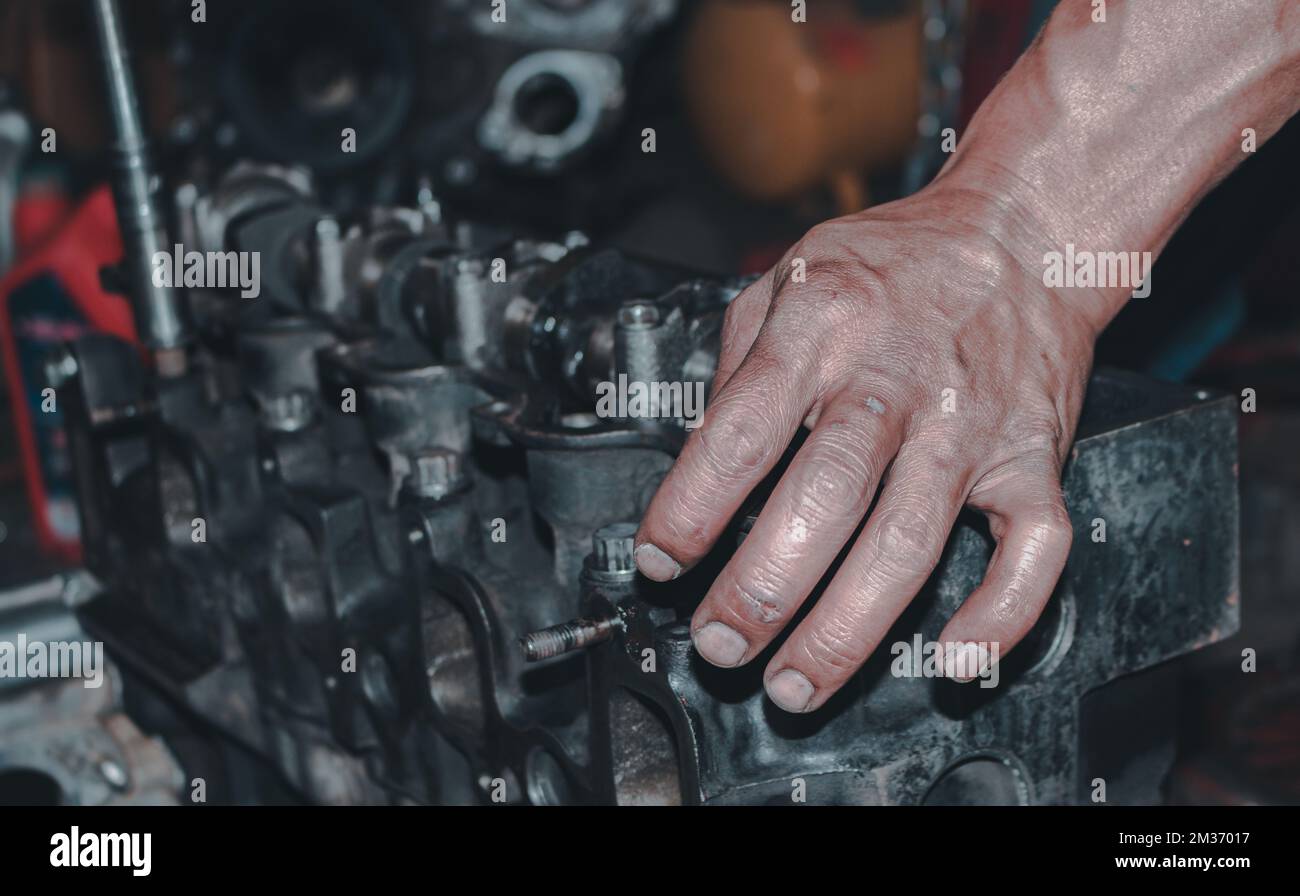 The auto mechanic repairing the engine of a car on the blurred ...