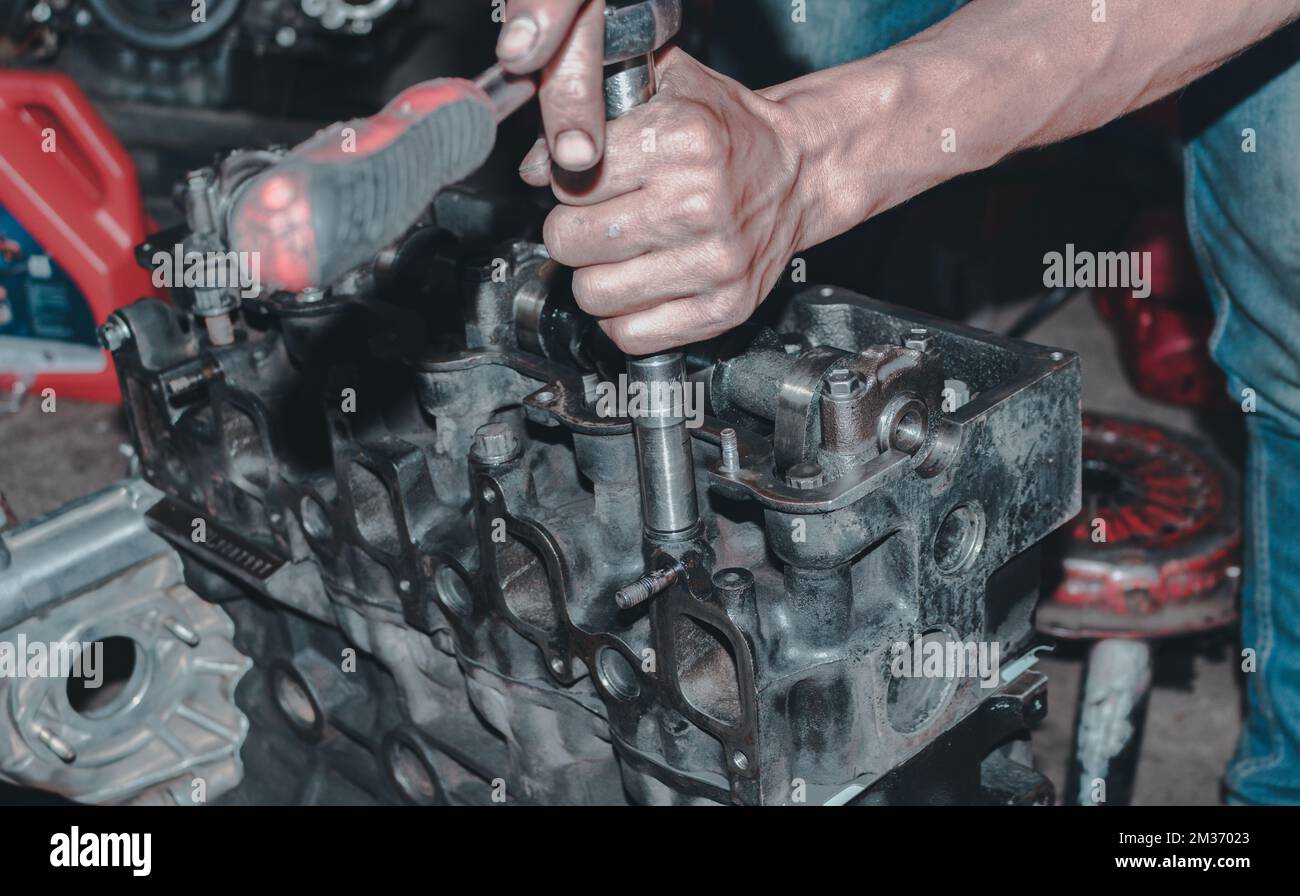 The auto mechanic repairing the engine of a car with different tools ...