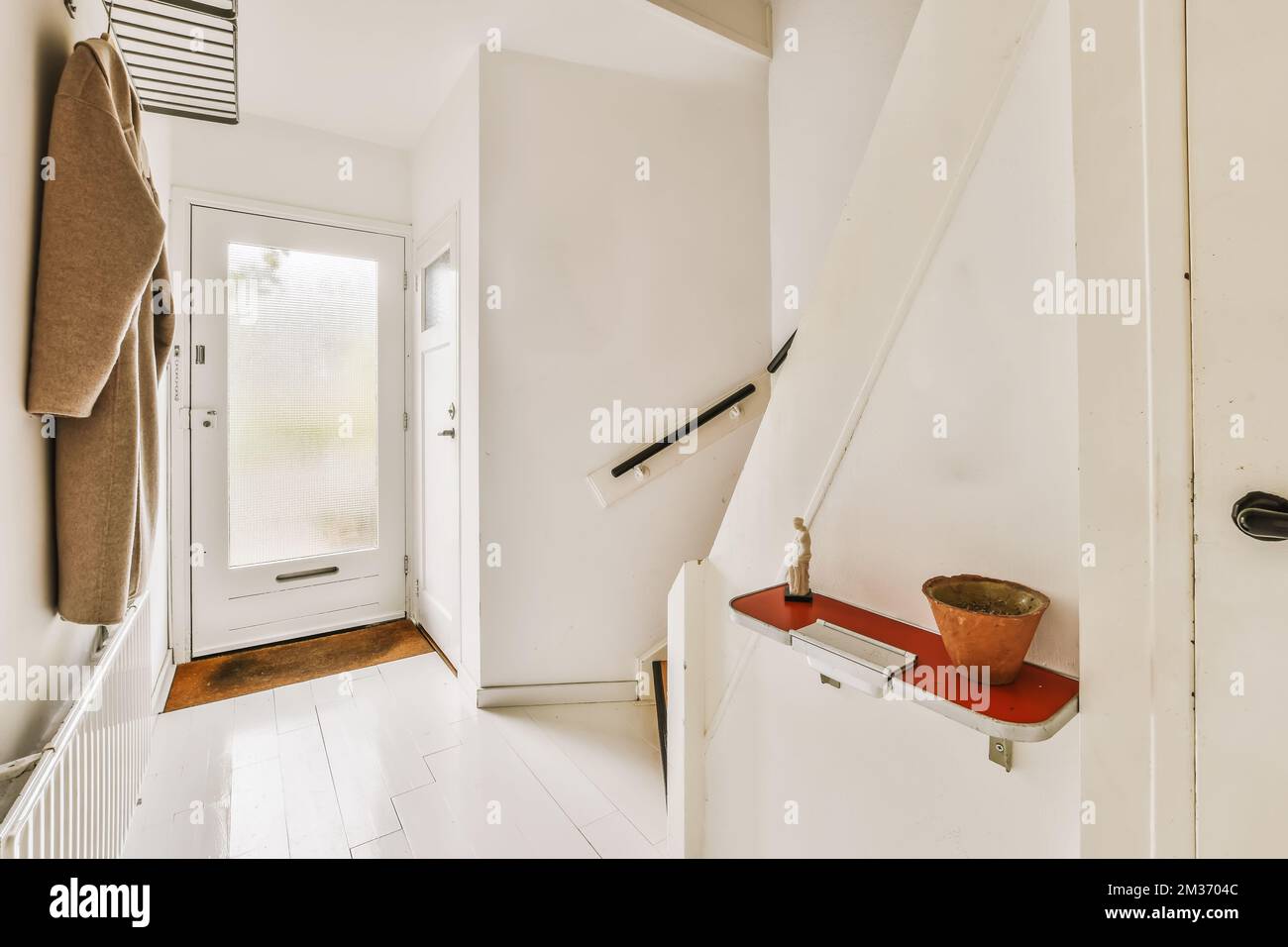 a hallway with white walls and wood flooring on the left side of the ...