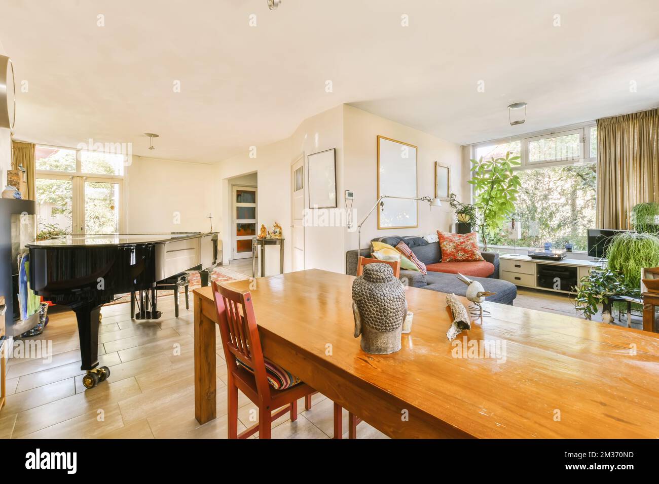 a living room with a piano in the middle and a couch on the other side ...