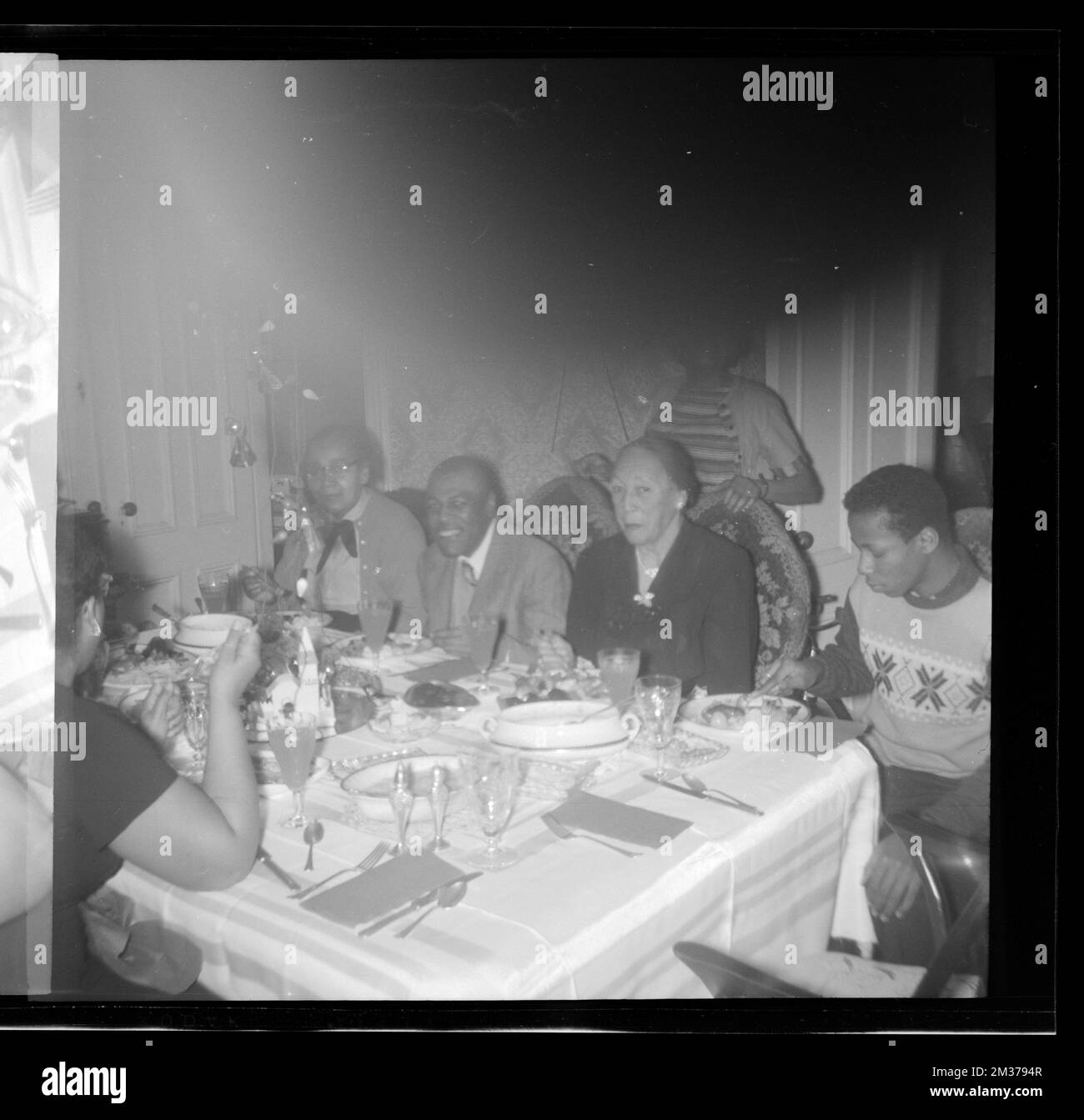 A group of people are seated eating at a dining table , Eating ...