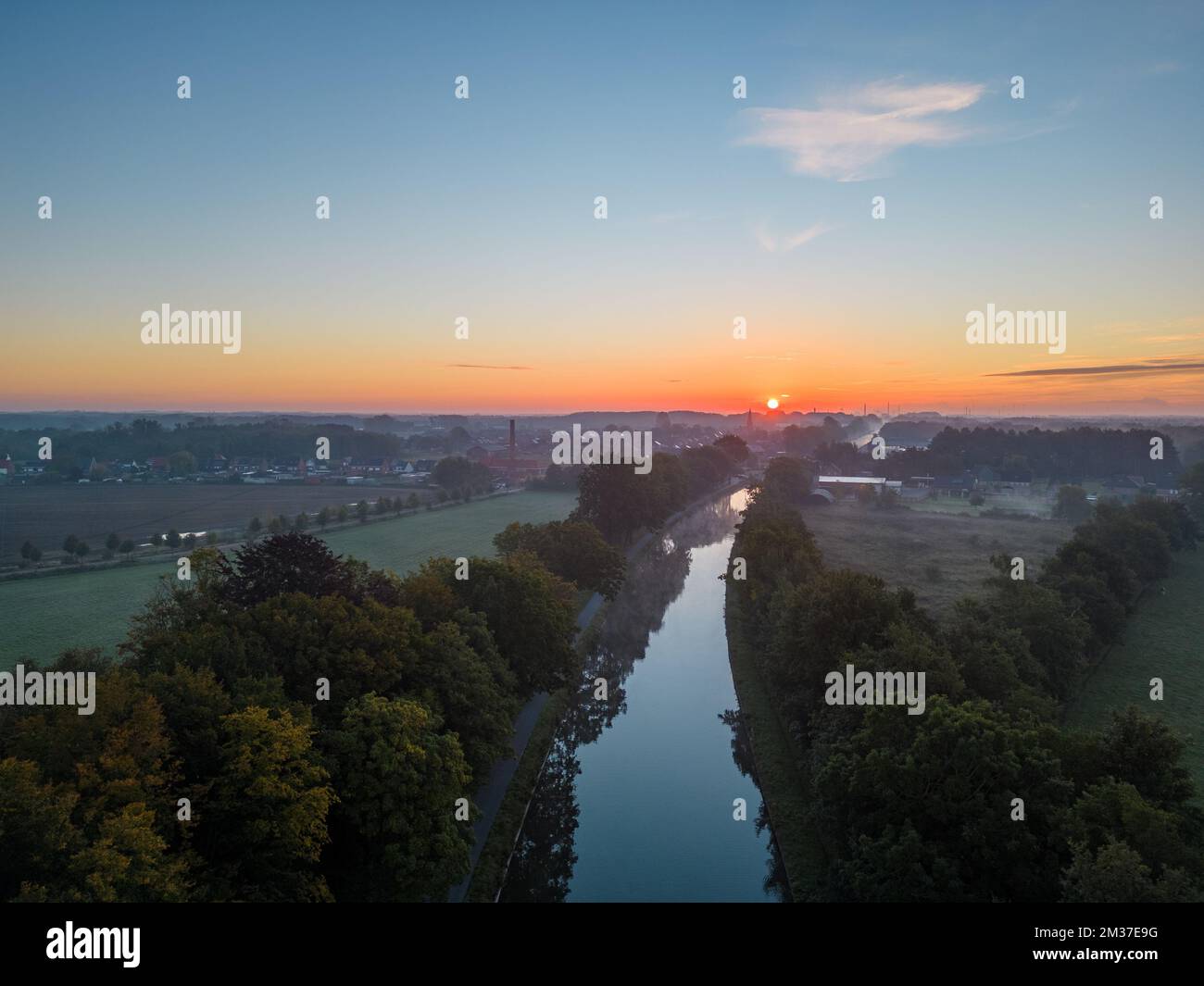 Aerial view, shot by a drone, of the sun rising or setting behind the ...