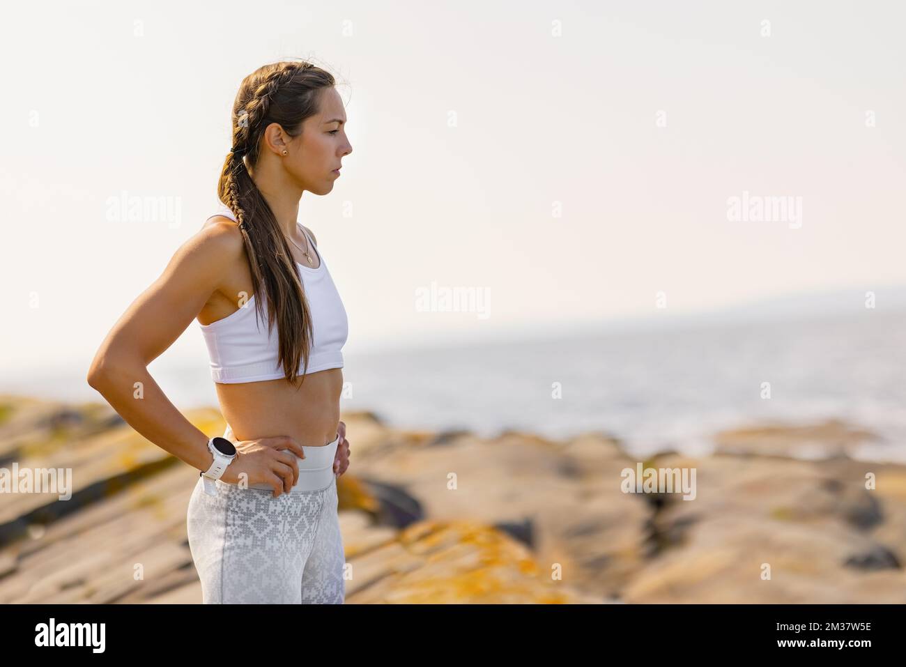 Contemplated Fit Woman Standing With Hands On Hip Stock Photo - Alamy