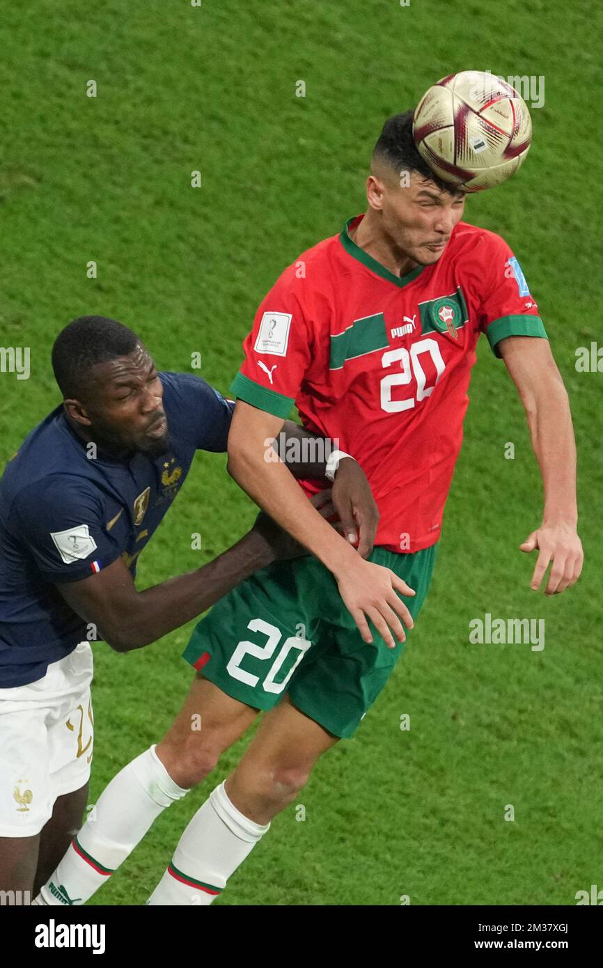 Al Khor, Qatar. 14th Dec, 2022. Achraf Dari (R) of Morocco heads the ...