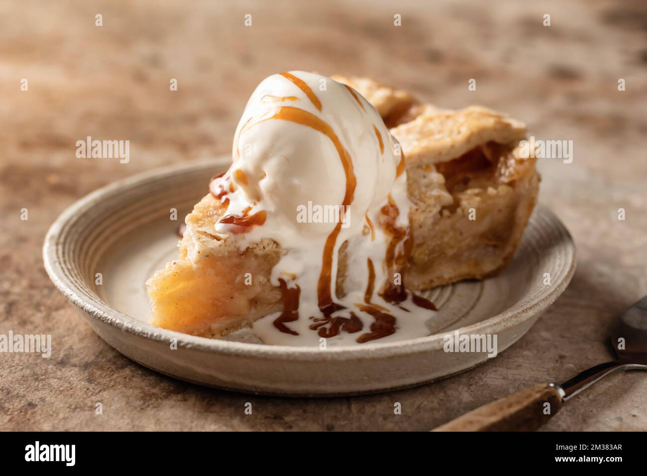 Piece of traditional apple pie with ice cream on brown textured ...