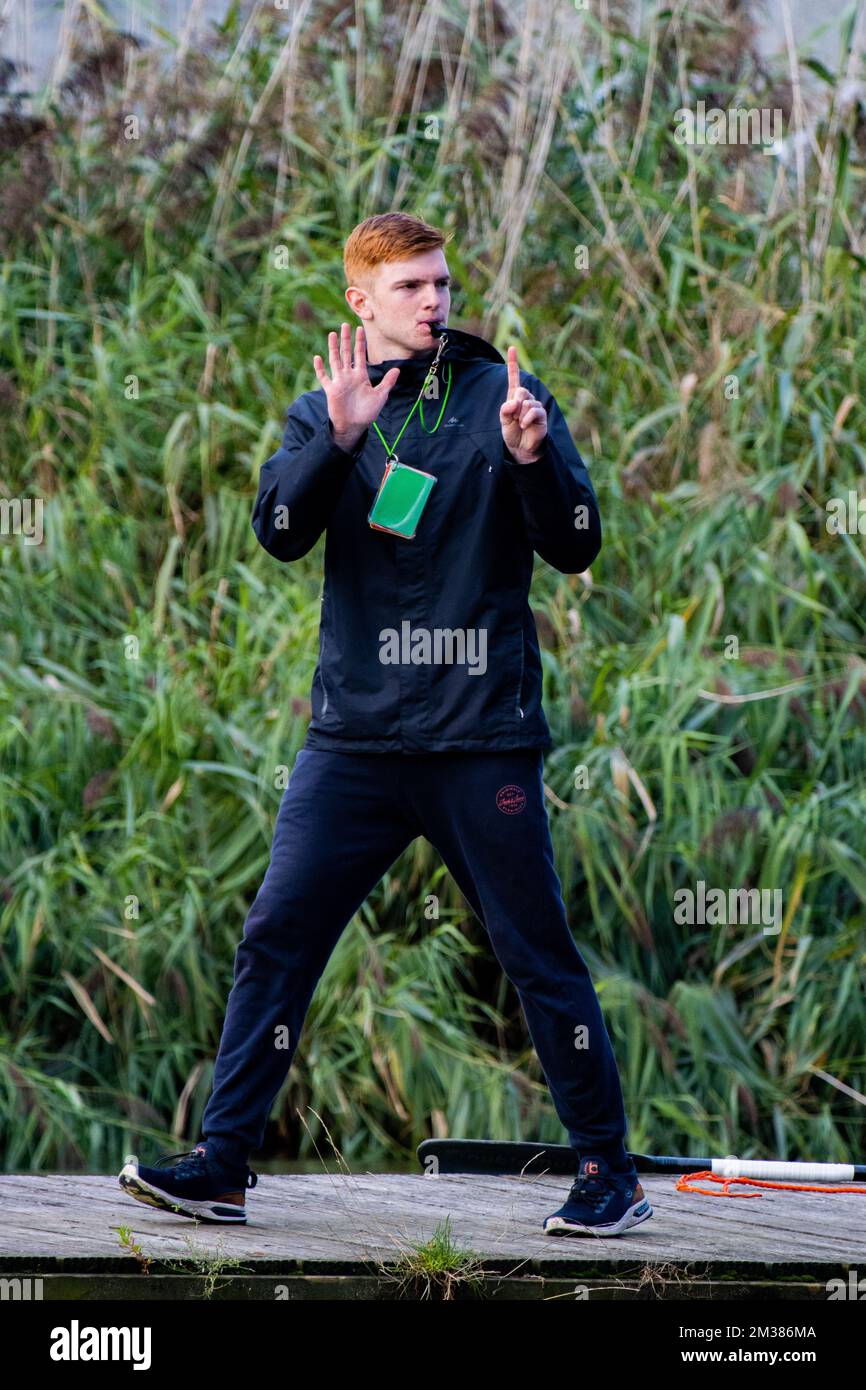 A vertical shot of a young referee standing on a dock at the canoe polo ...