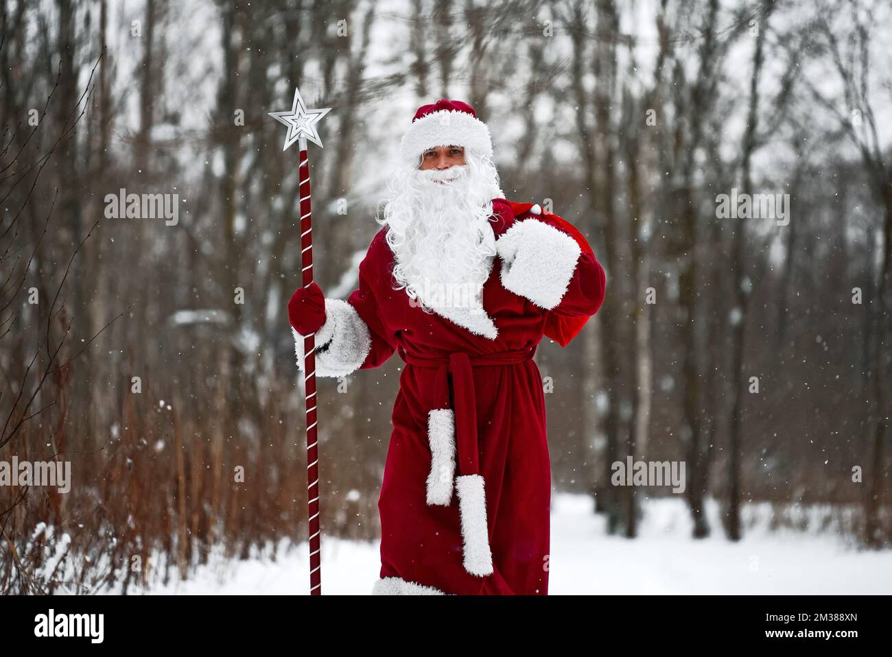 Santa Claus with magic staff and sack of Christmas gifts Stock Photo ...