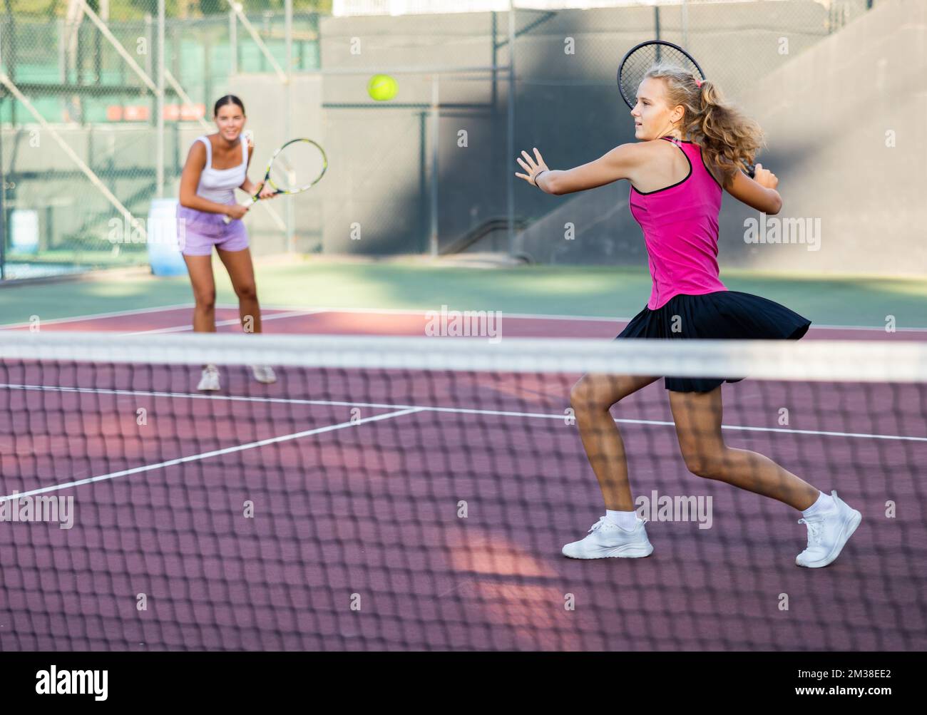 Female player playing tennis in tennis court outdoor behind net Stock ...