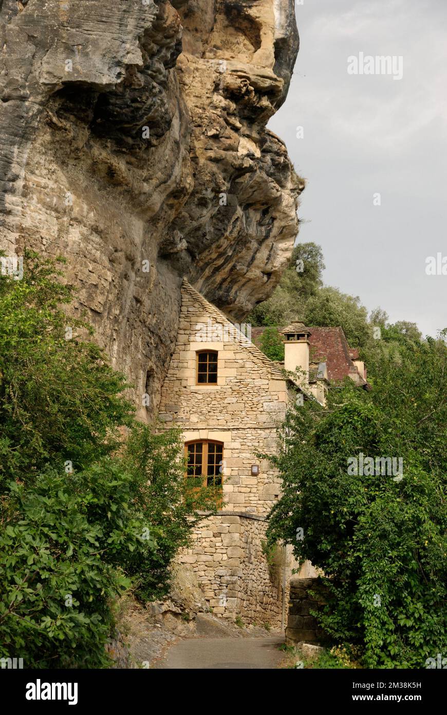 Stone house built against a rock in France Stock Photo - Alamy