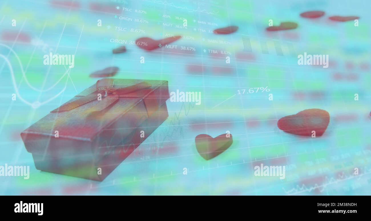 Image of gift box and heart shapes over moving graphs and trading board ...