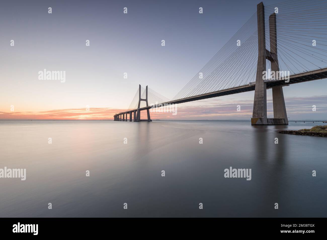 Background with colourful sunrise on the Lisbon bridge. The Vasco da ...
