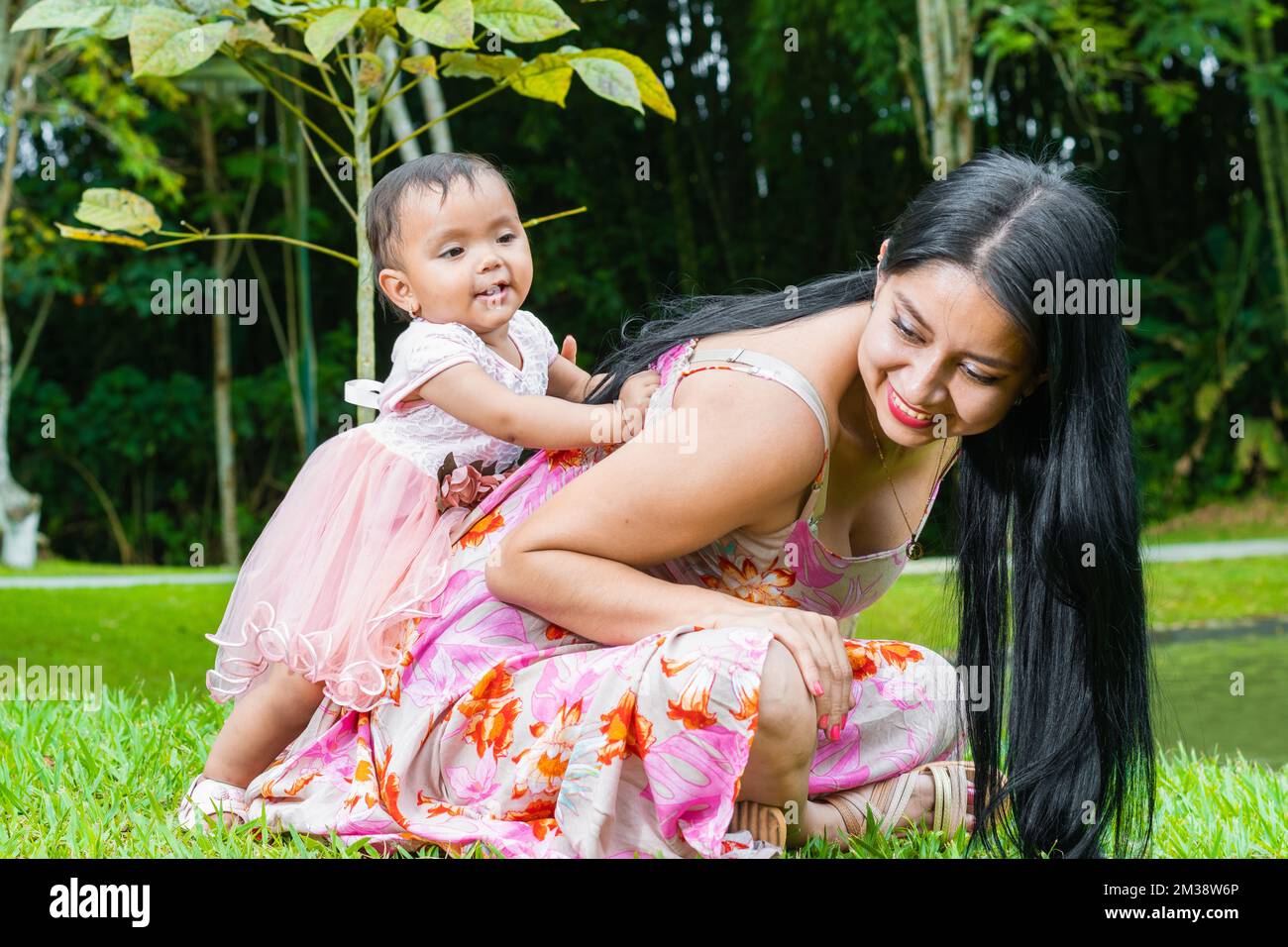 beautiful brunette latina baby, pushing her mother from behind. woman ...